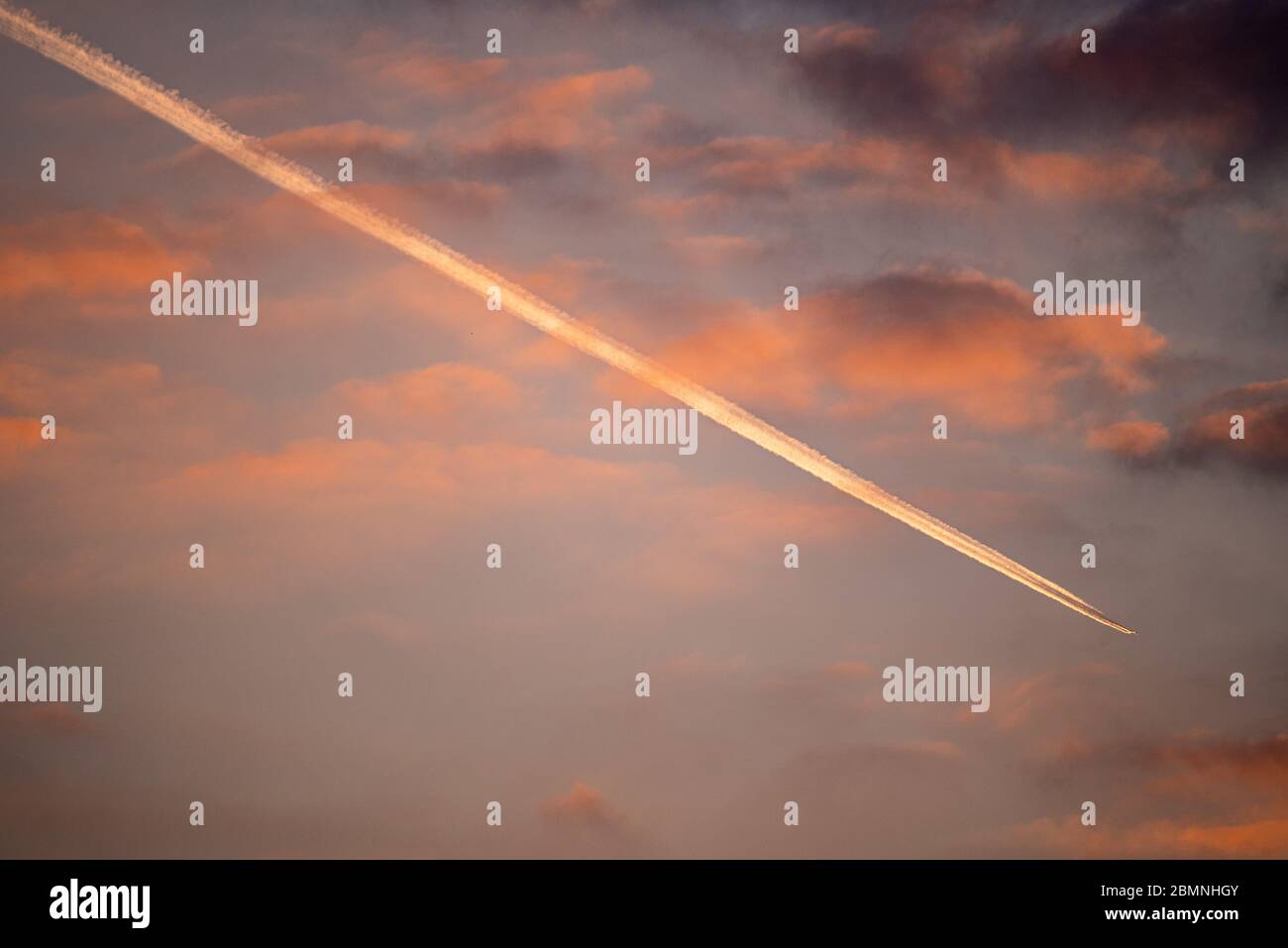 Aircraft contrail, vapour trail in the dawn sky en route to Heathrow ...