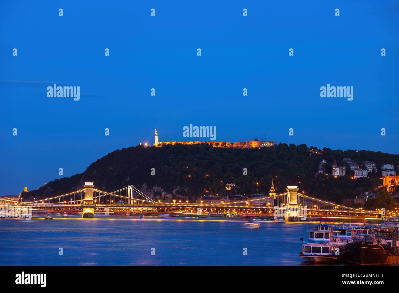 Gellert Hill with Citadel in Budapest at night, illuminated bridges on ...