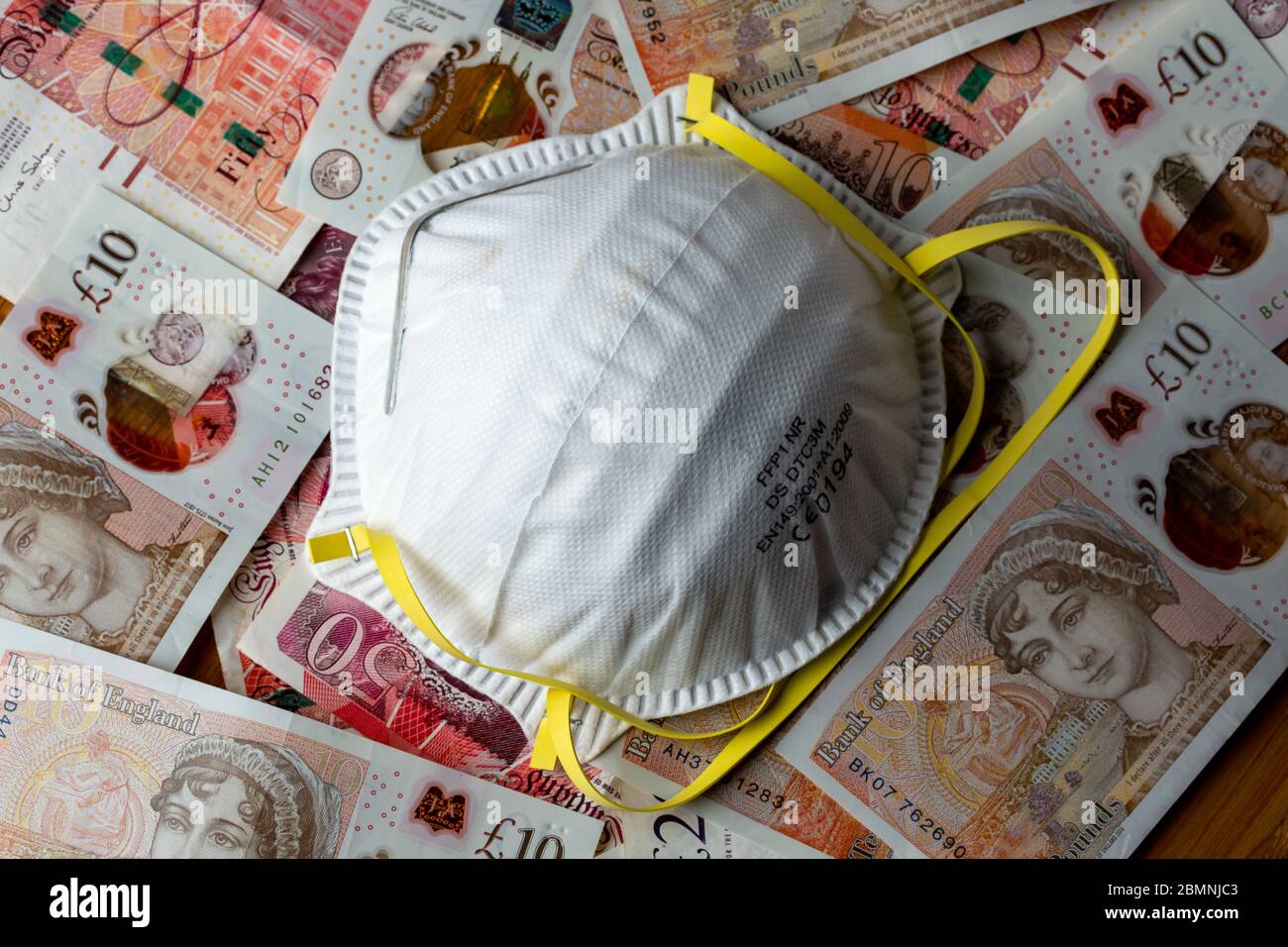Face mask laying on bank notes money, British sterling notes Stock ...