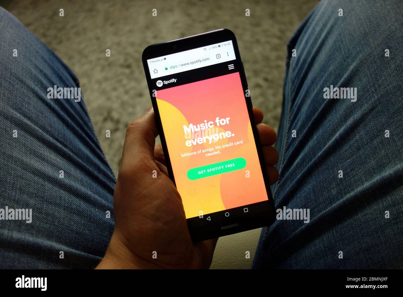 Man holding Huawei smartphone with Spotify website. Digital device ...