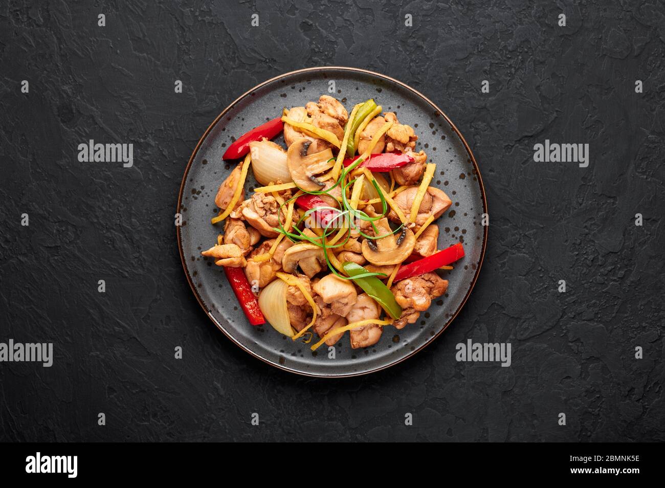 Thai Ginger Chicken or Gai Pad King in dark plate at black slate ...