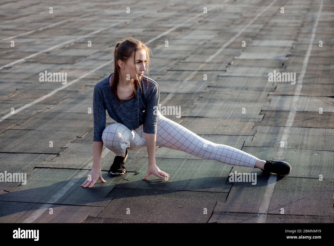 Female runner stretching legs on running track Stock Photo - Alamy