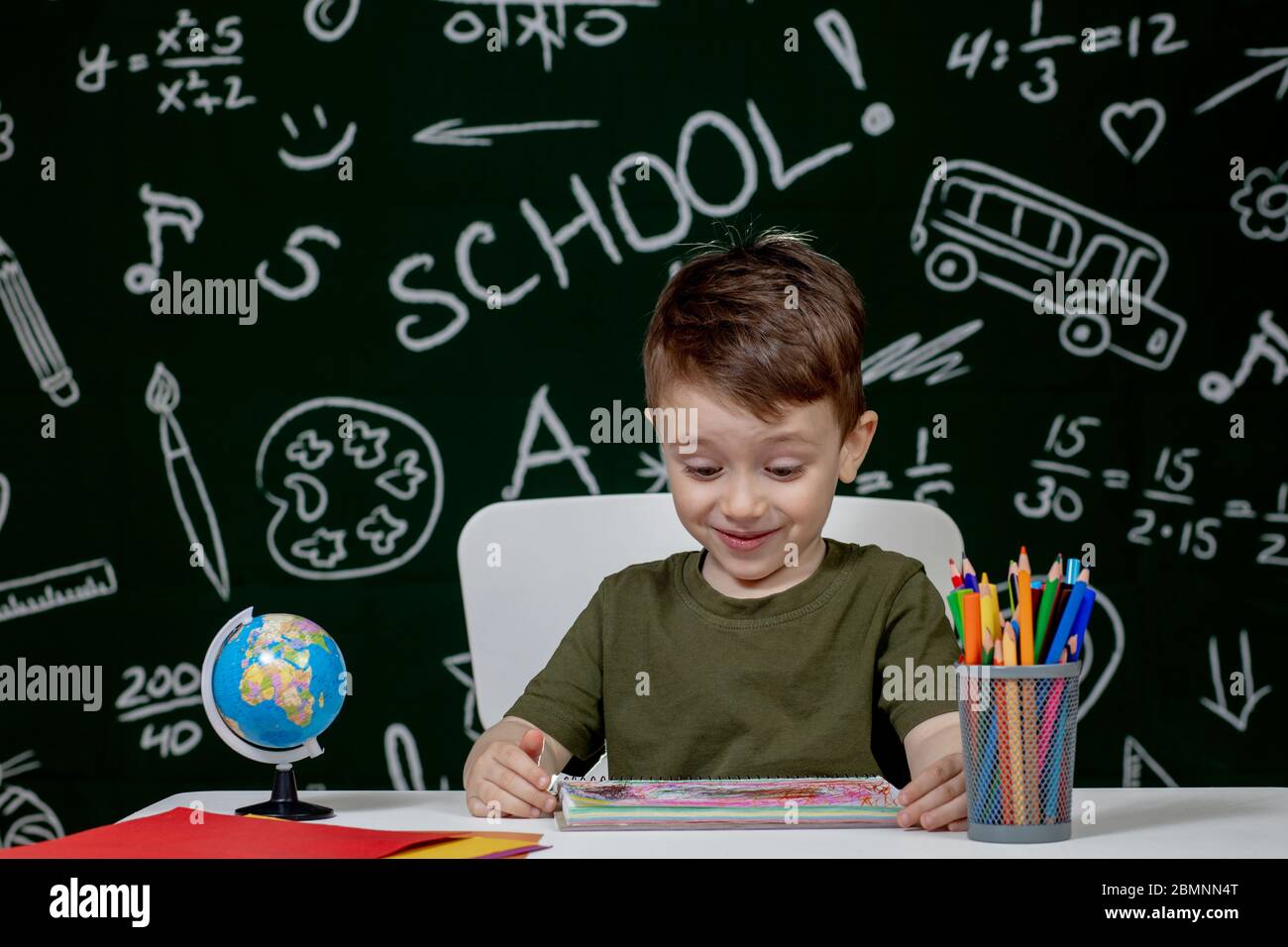Cute child boy doing homework. Clever kid drawing at desk. Schoolboy ...