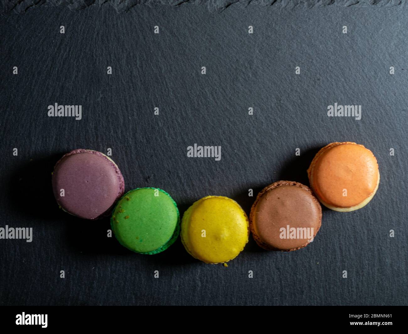 Five macaroons of different colours arranged in the form of a smile on ...
