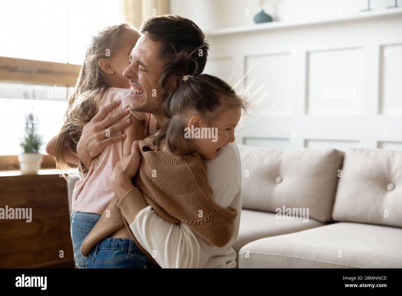 Father hugging daughters hi-res stock photography and images - Alamy