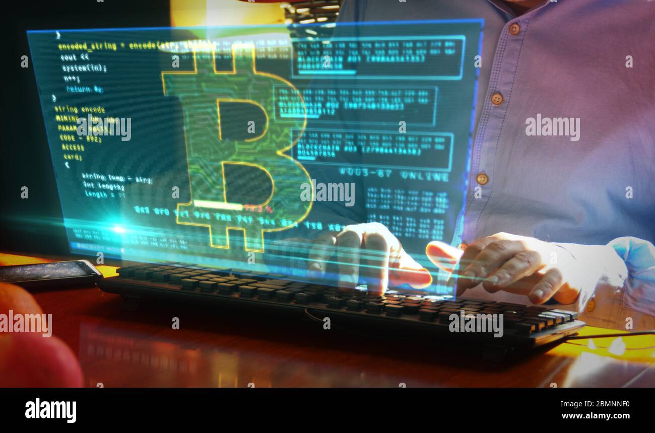 Hacker typing on the keyboard and Bitcoin mining on hologram screen on ...