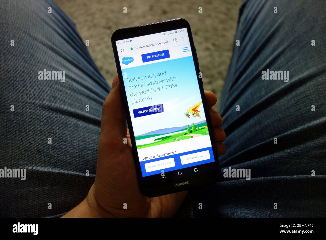 Man holding Huawei smartphone with Salesforce.com website displayed ...
