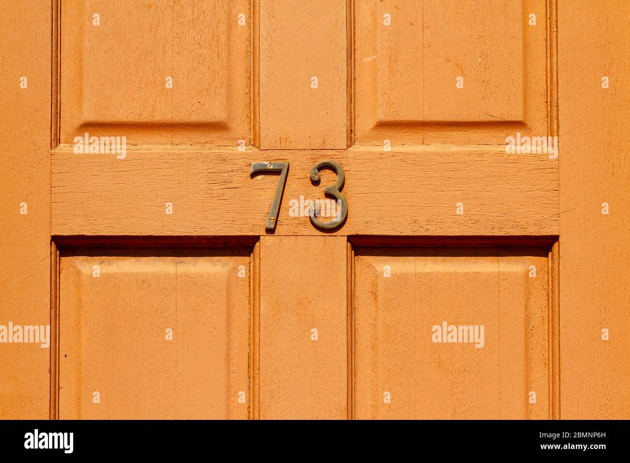 House number 73 on a light wooden front door Stock Photo - Alamy