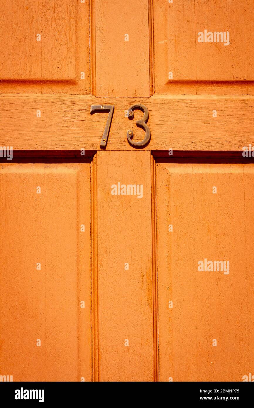 House number 73 on a light wooden front door Stock Photo - Alamy