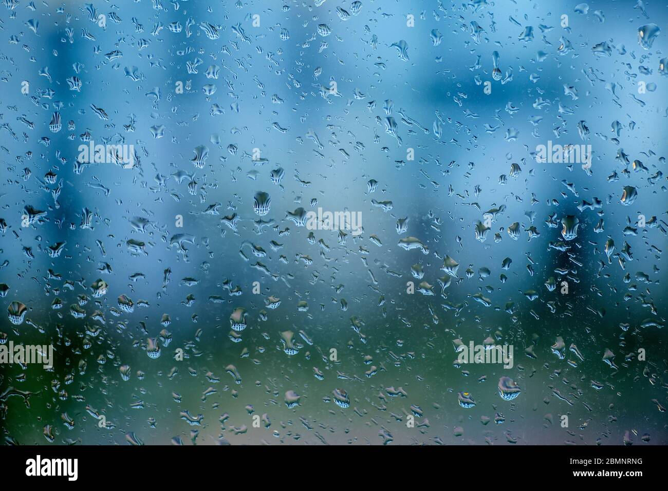 Raindrops on a window glass on a rainy day. Rain, cloudy day, sadness ...