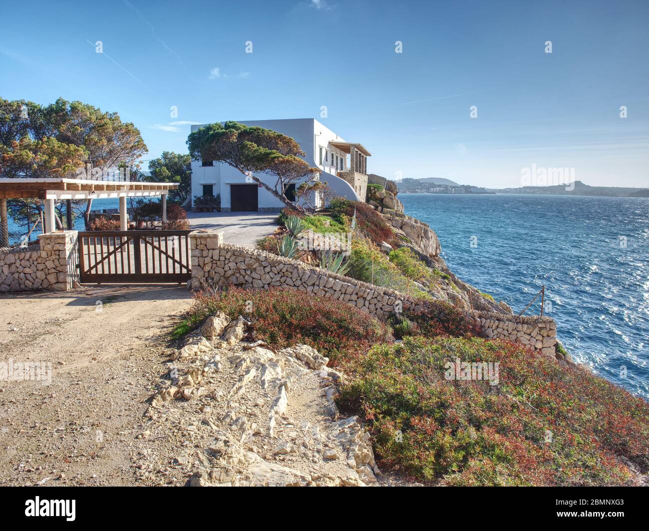 House standing on a cliff by the sea. Way and gate of a house on a ...