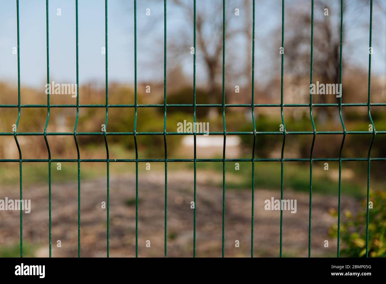 Steel grill fence with blurred wire background Stock Photo - Alamy
