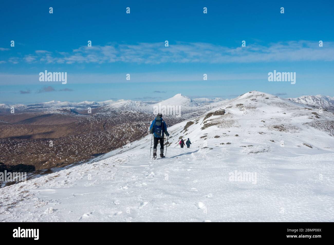 3 male hikers descending from the summit cairn of Ben Vorlich, a munro ...
