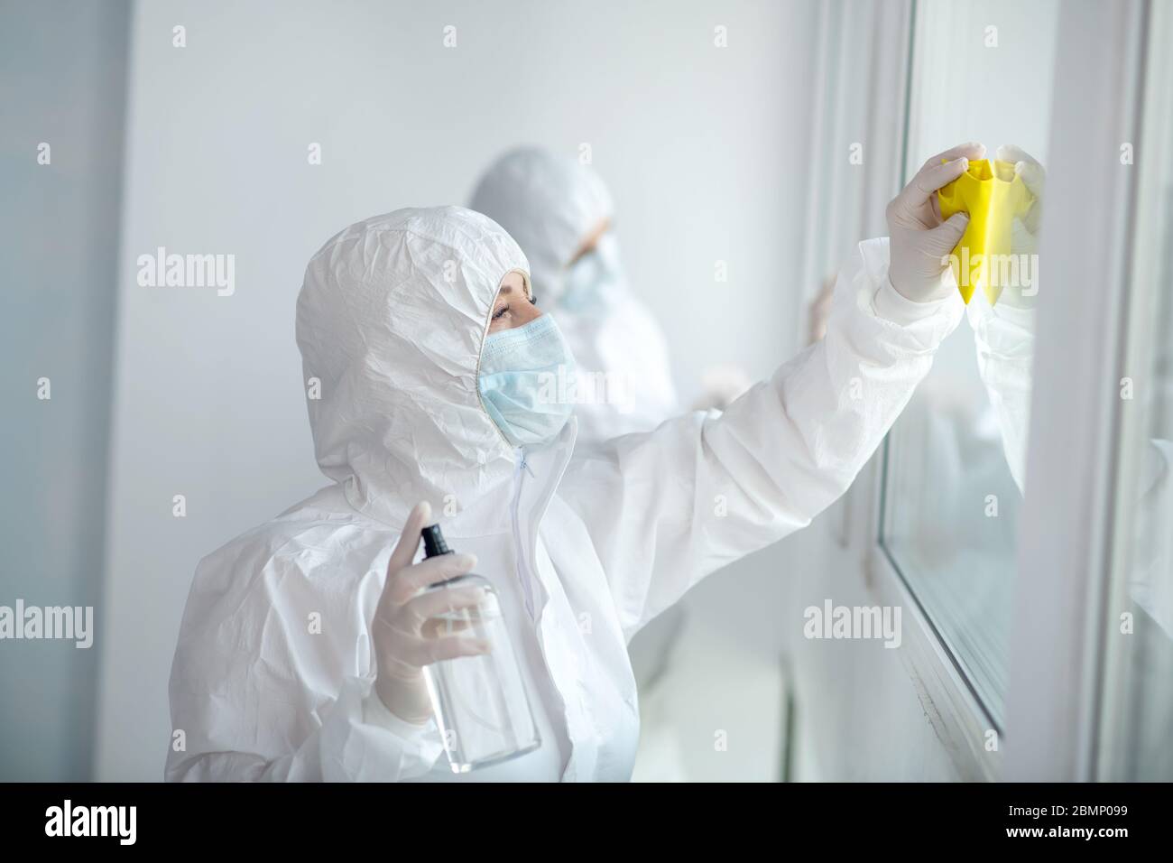 Medical workers in protective clothing and medical masks cleaning and ...