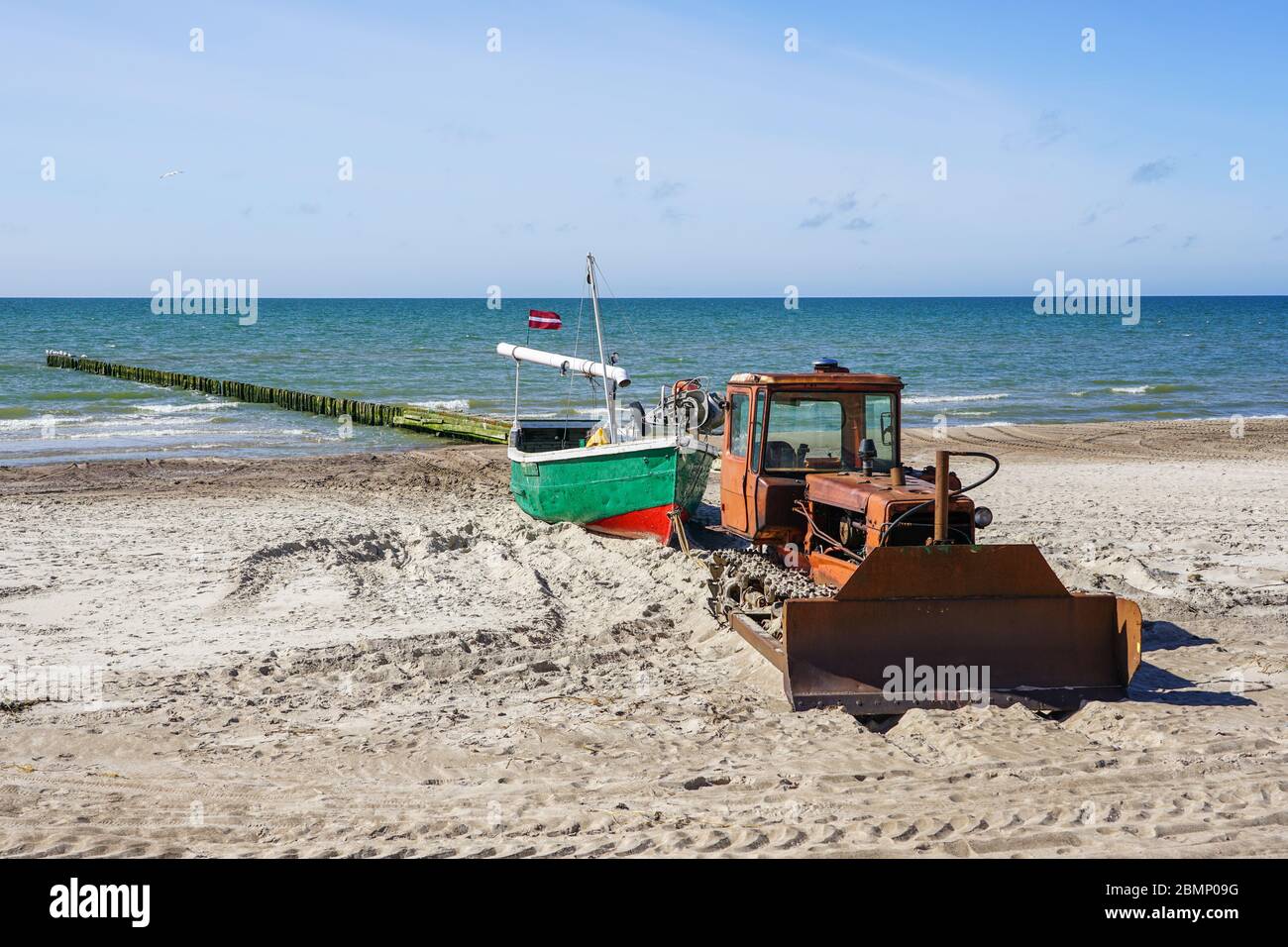 a heavy bulldozer pulls a fishing boat out of the sea Stock Photo - Alamy