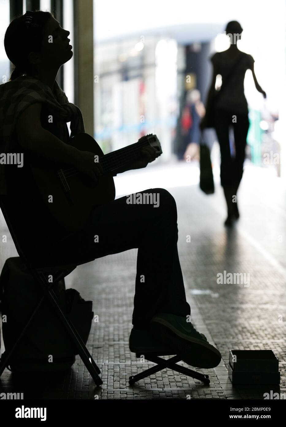 A silhouette of a girl singer sitting and playing the guitar for the ...