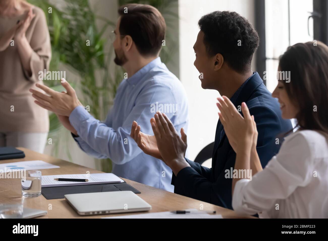 Smiling african american businessman clap hands with diverse colleagues ...