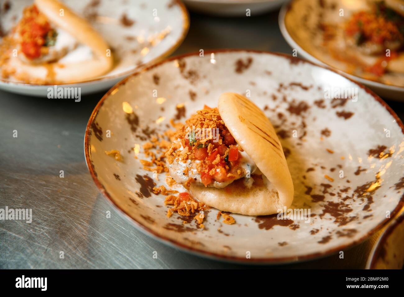 Steamed kebab with rotan in a bun. The dish lies in a round plate ...