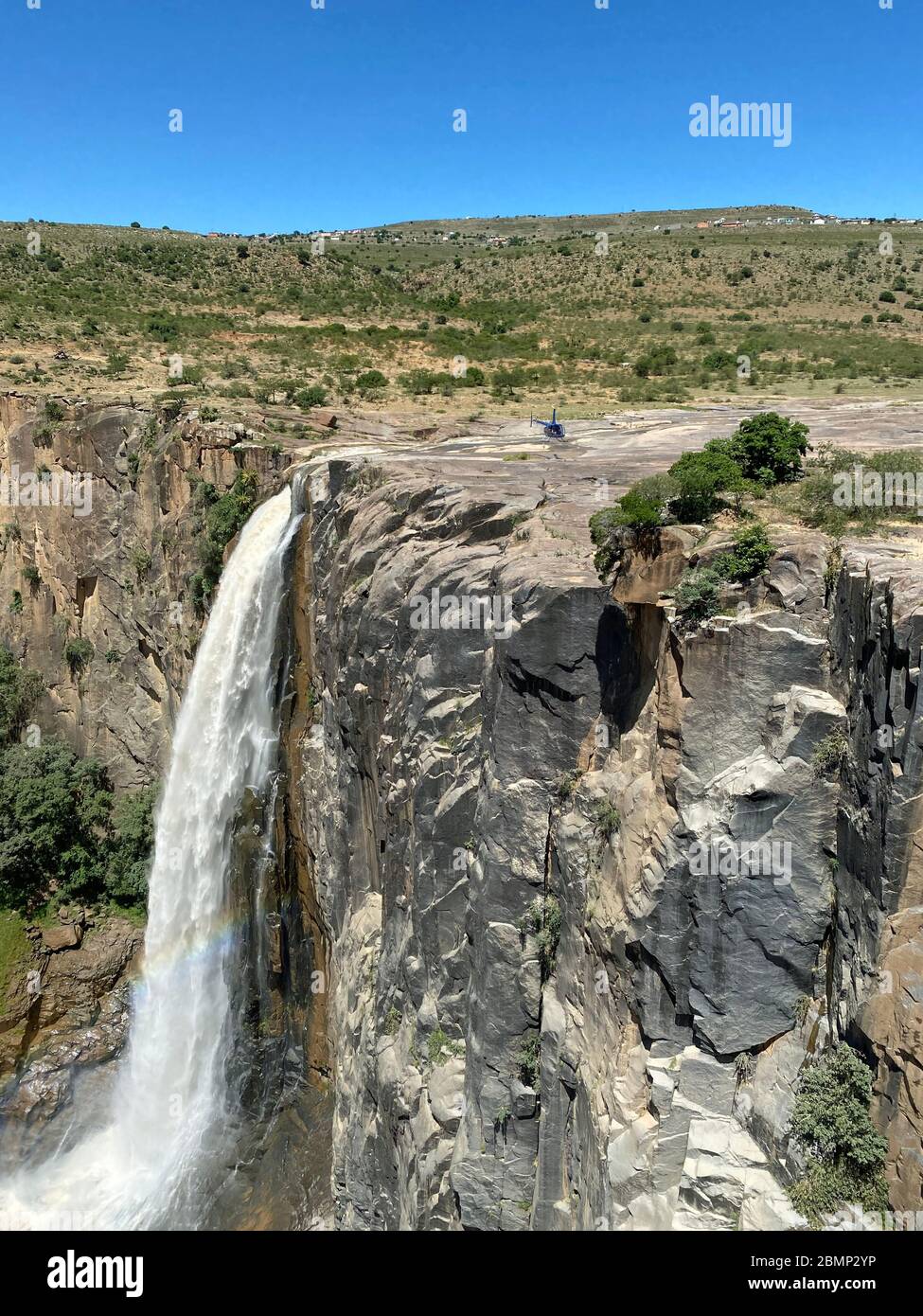 Above a waterfall a helicopter pilot tries to land his plane. It is ...