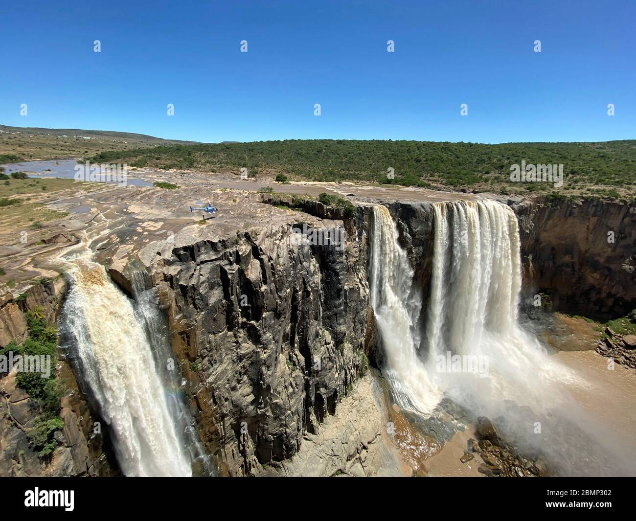 Above a waterfall a helicopter pilot tries to land his plane. It is ...