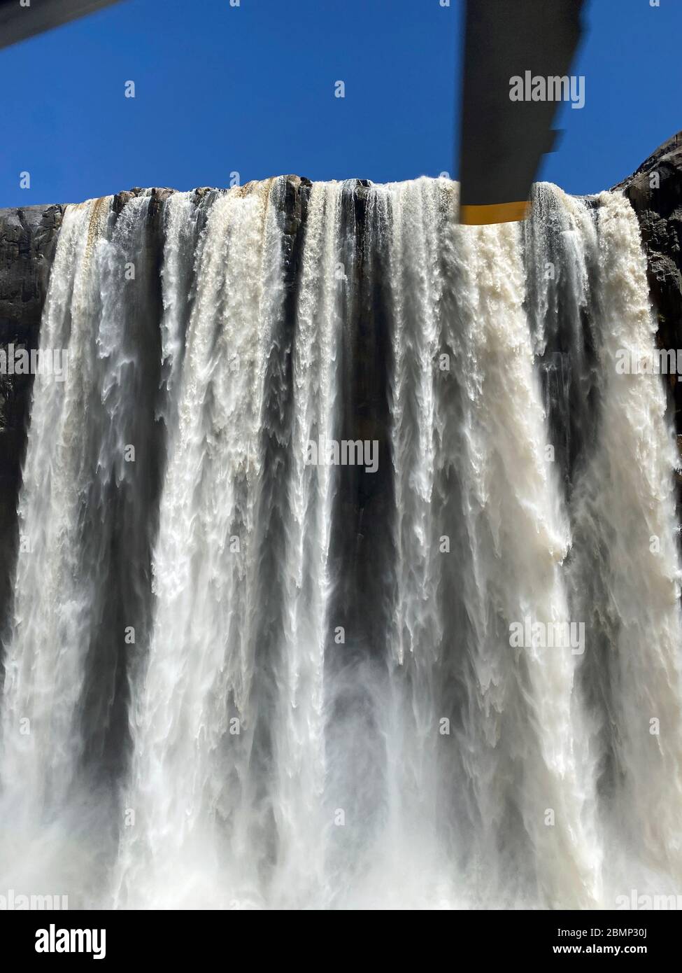 The view from the helicopter's cockpit below a large waterfall is not ...