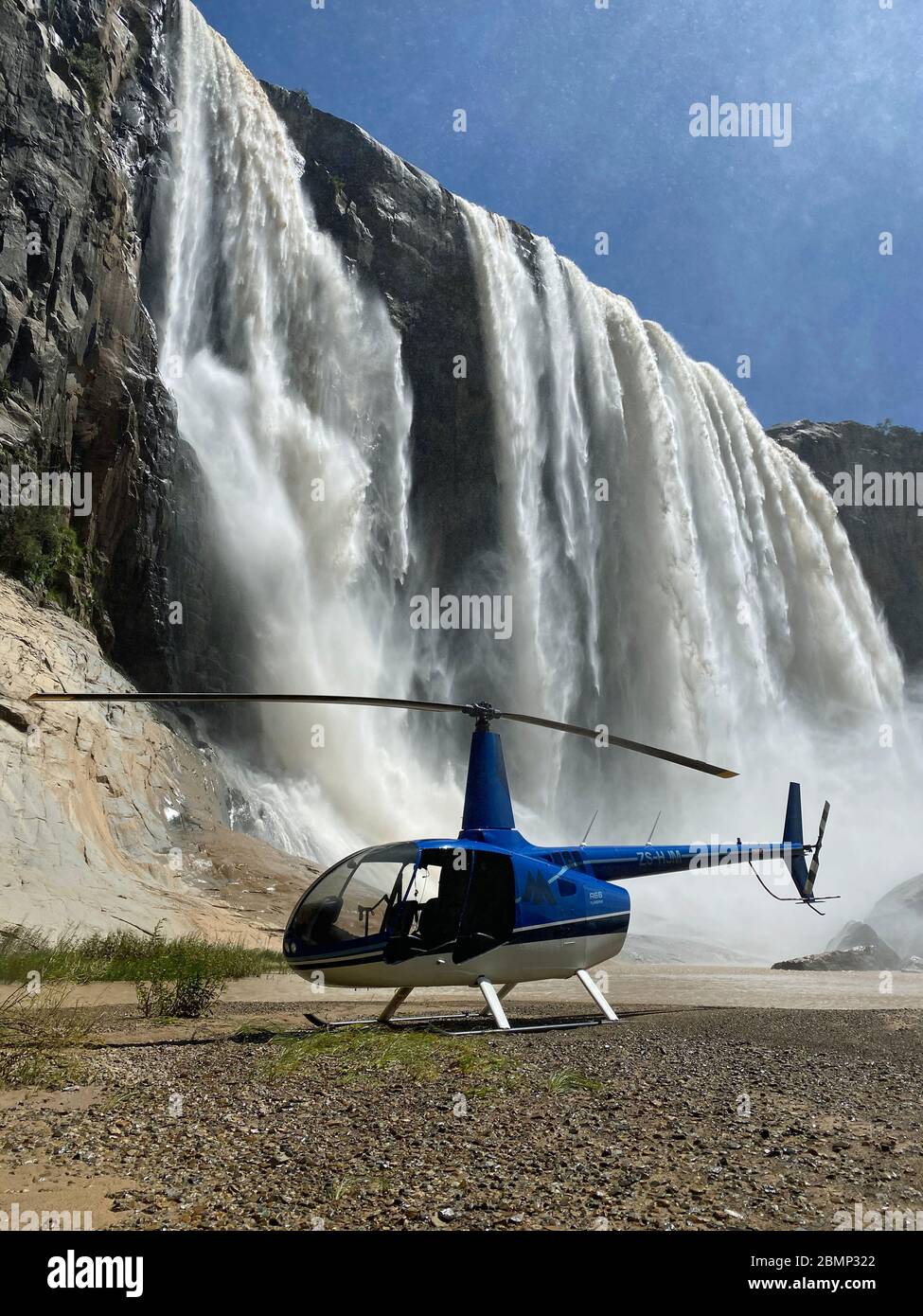 A pilot has parked his helicopter below a large waterfall. Impressive ...