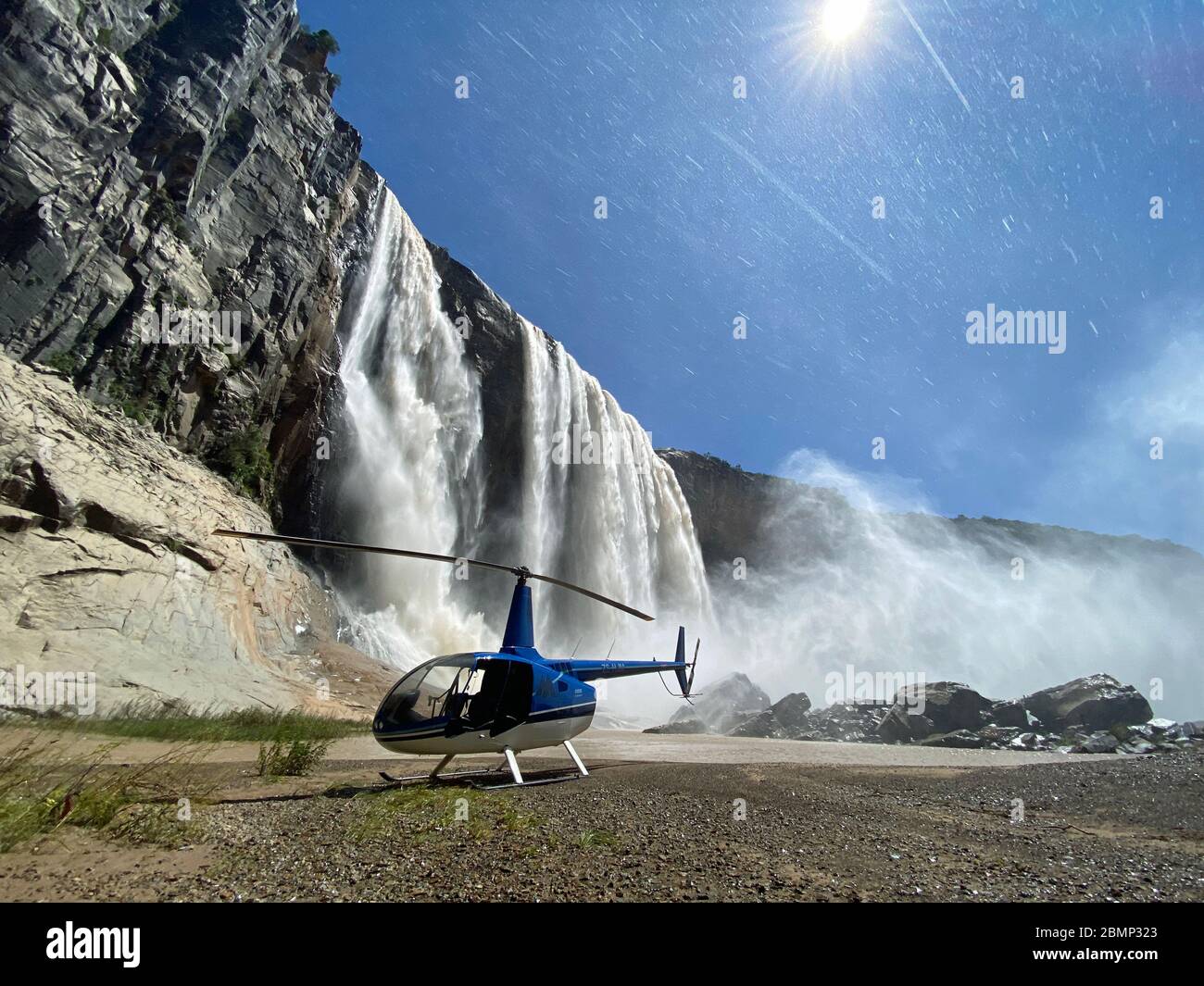 A pilot has parked his helicopter below a large waterfall. Impressive ...