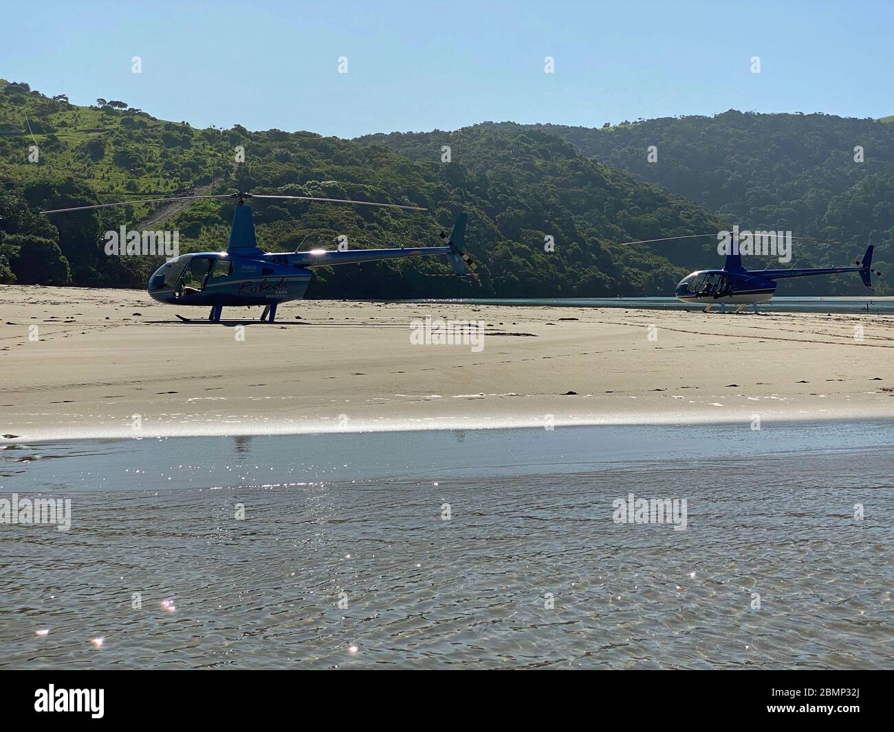 These two helicopters have landed on the sandy beach. The pilots allow ...