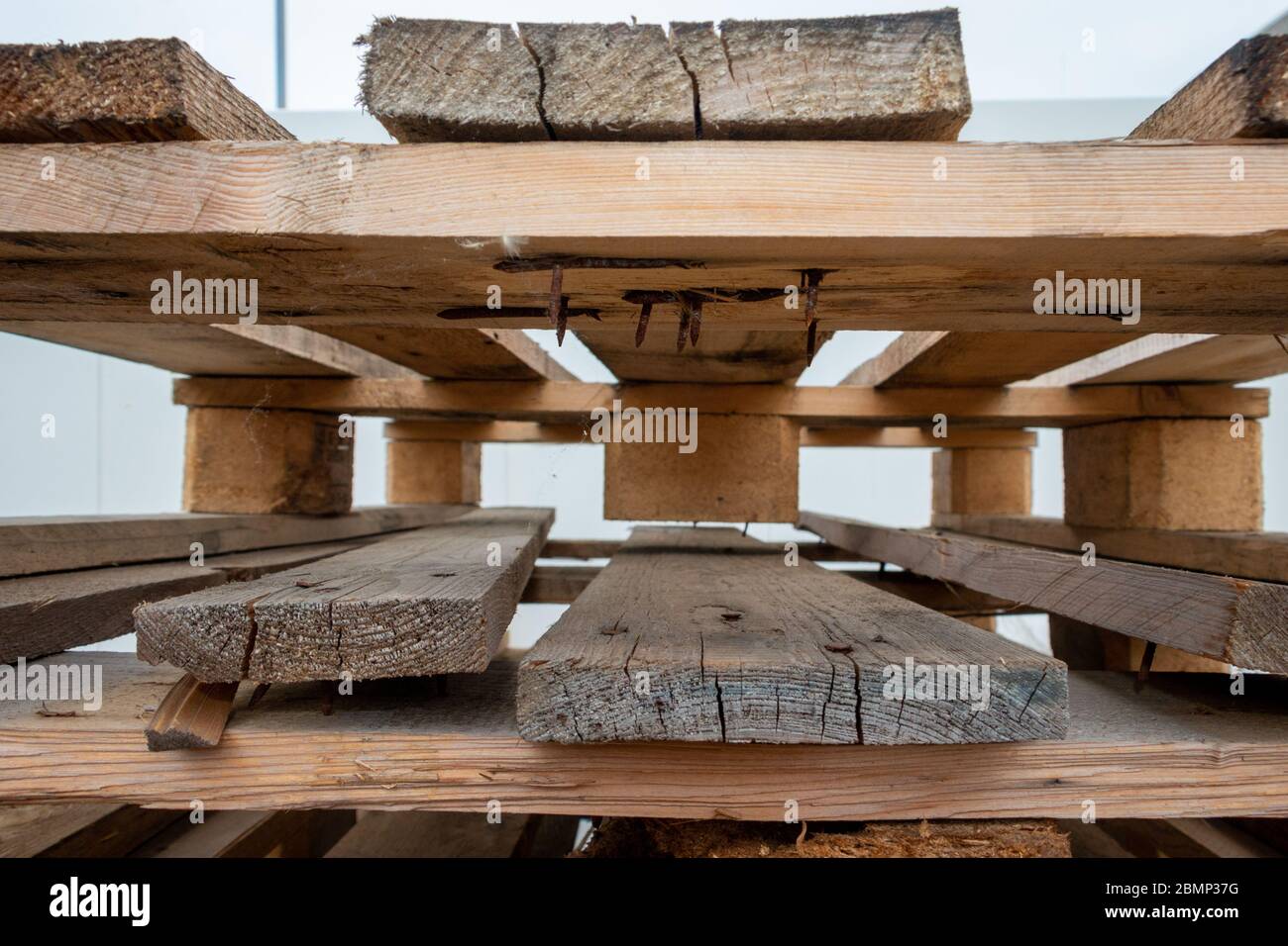 stacked pallets with wooden planks and rusty nails and screws, stored ...