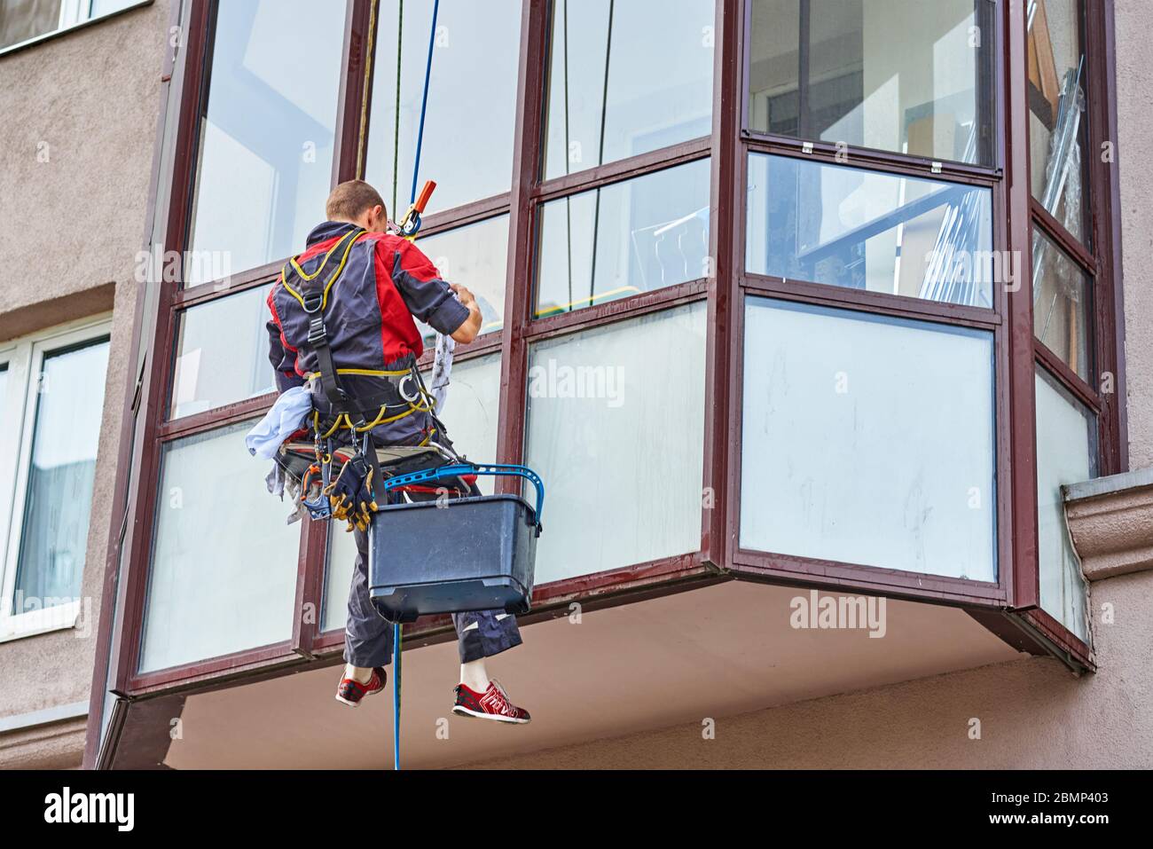 Industrial climber cleaning window on building in city Stock Photo - Alamy