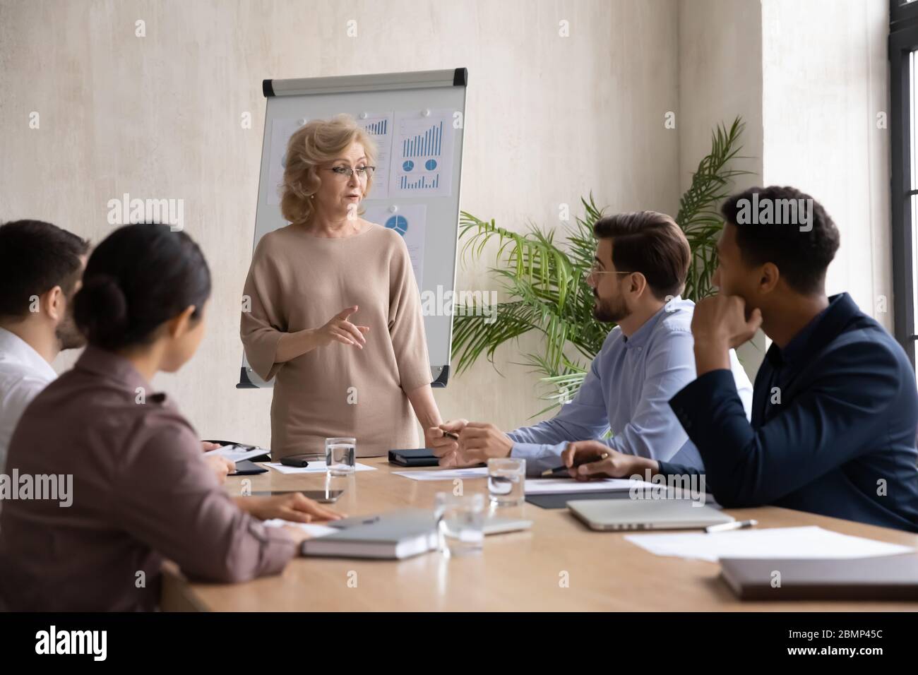 Confident mature 60 year old businesswoman presentation new project ...