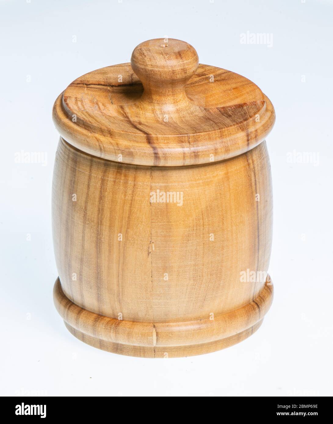 Small wooden barrel-shaped container with closed lid, vertical image on ...