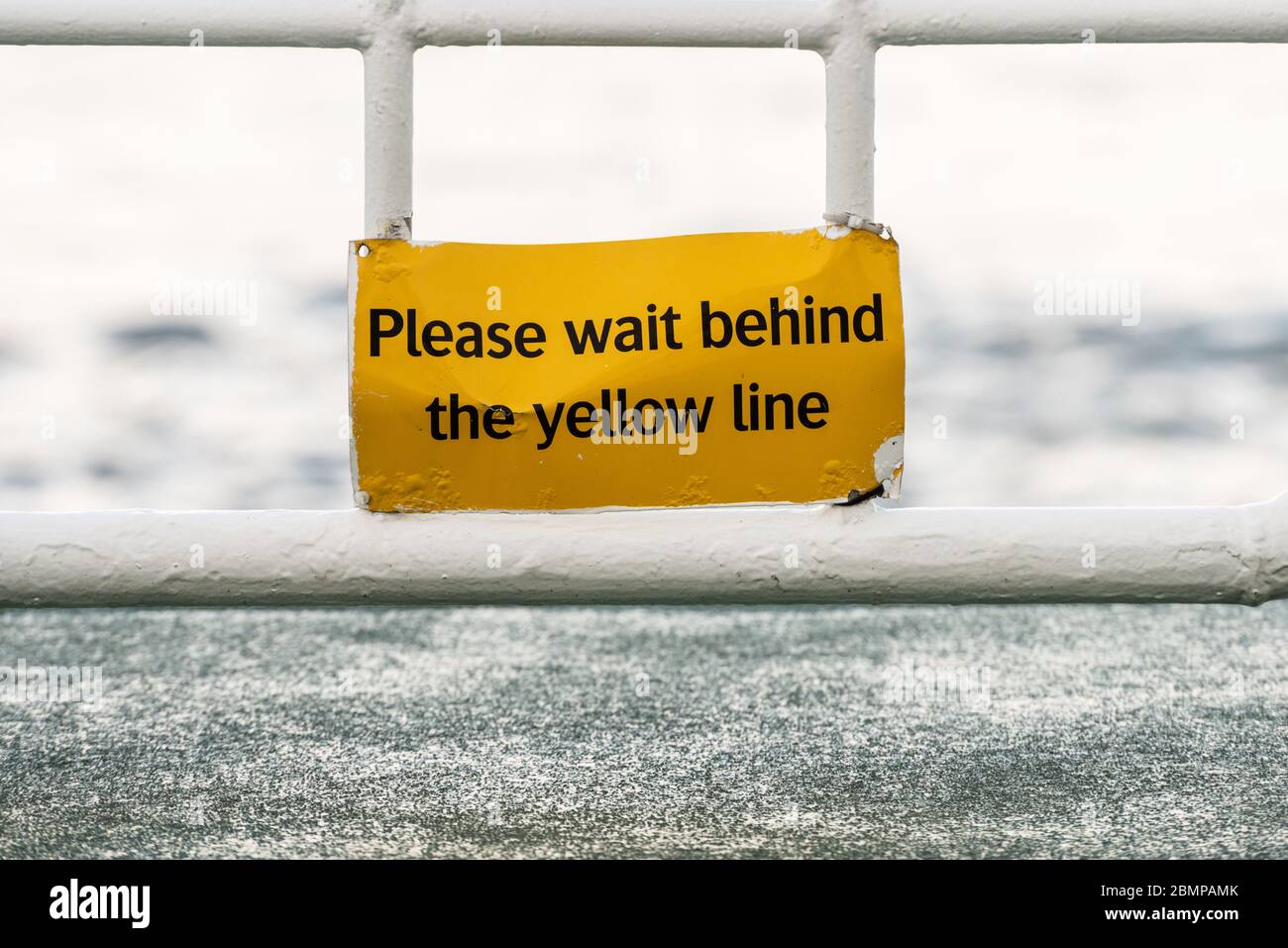 Yellow sign that says please wait begind the yellow line Stock Photo ...