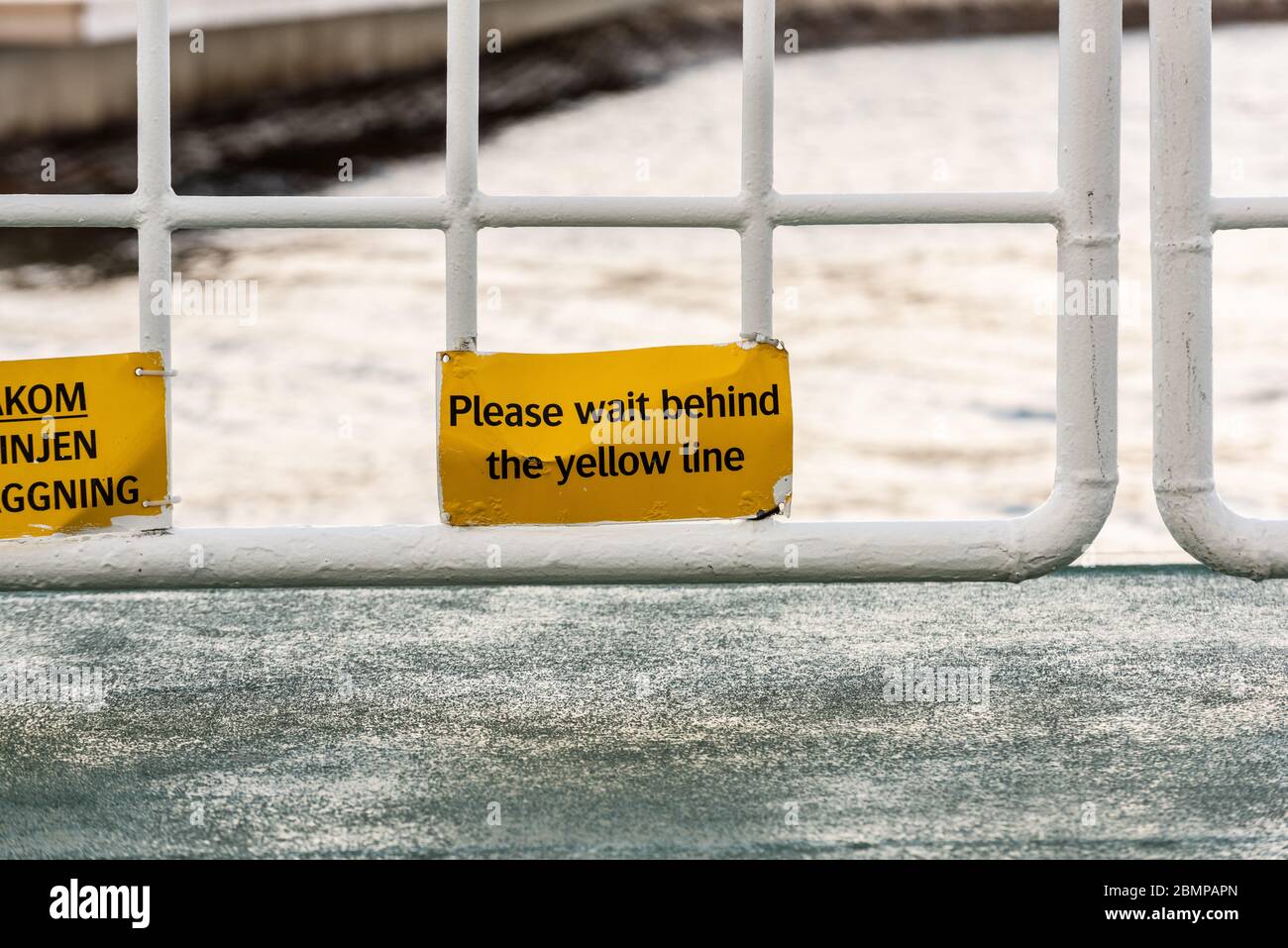 Yellow sign that says please wait begind the yellow line Stock Photo ...