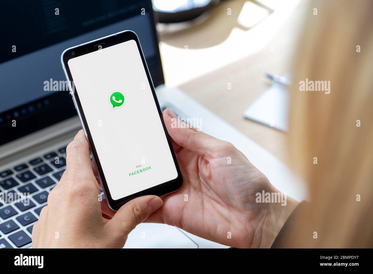 Girl with whatsapp start screen. She's with smartphone in her hands and ...