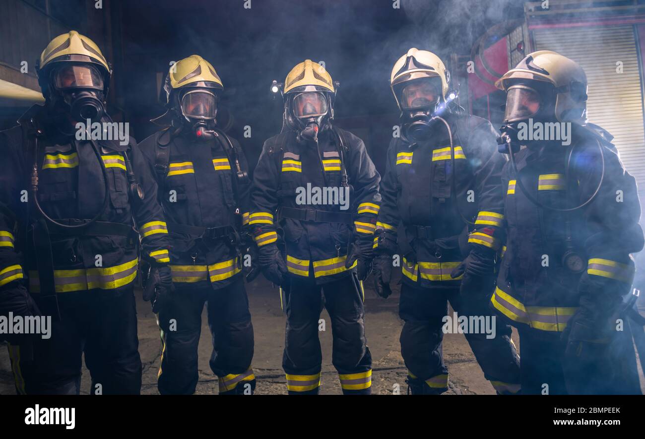 Portrait of group of firefighters in the middle of the smoke of the ...