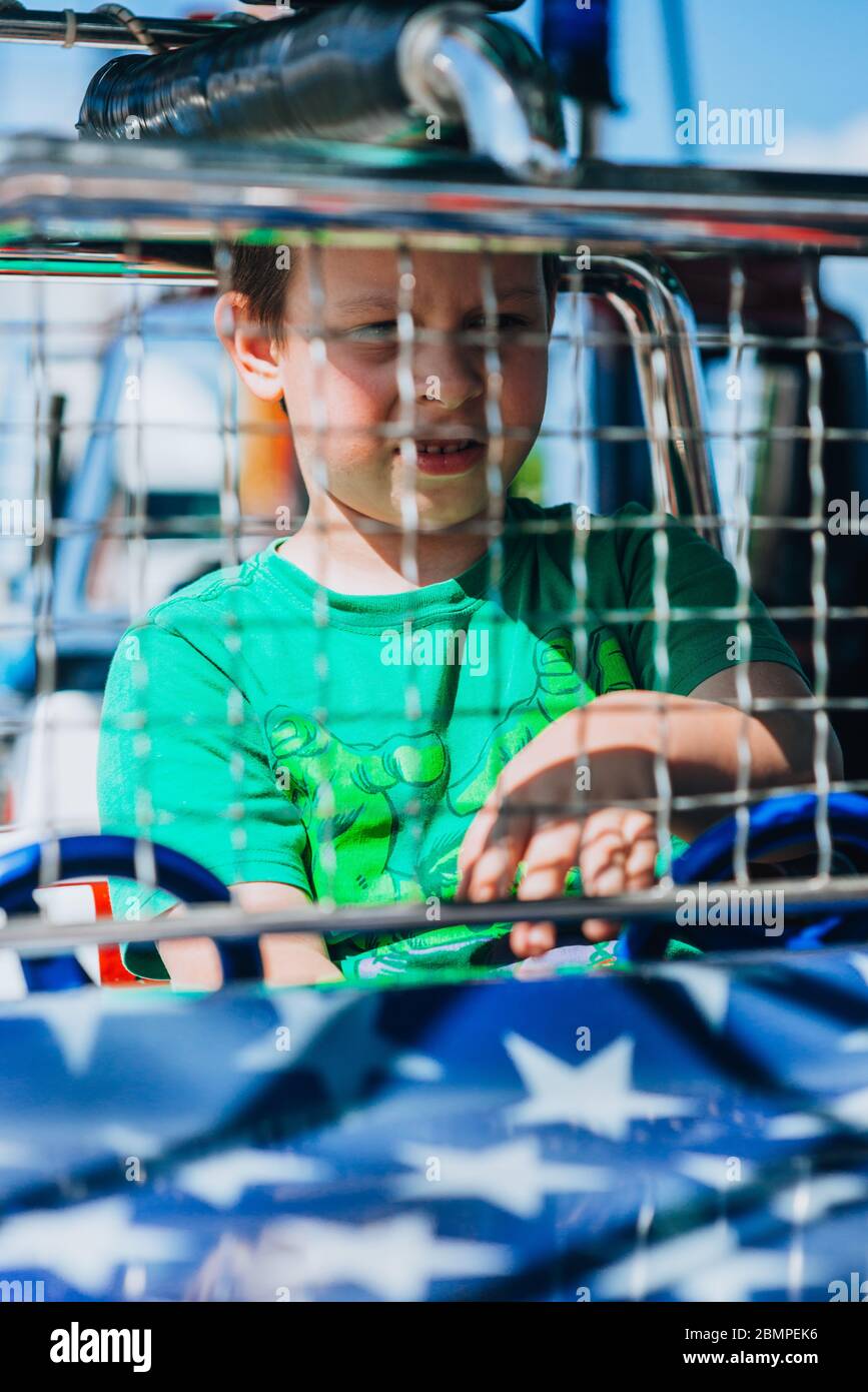 Little cheerful kid playing and having fun on the merry go round Stock ...