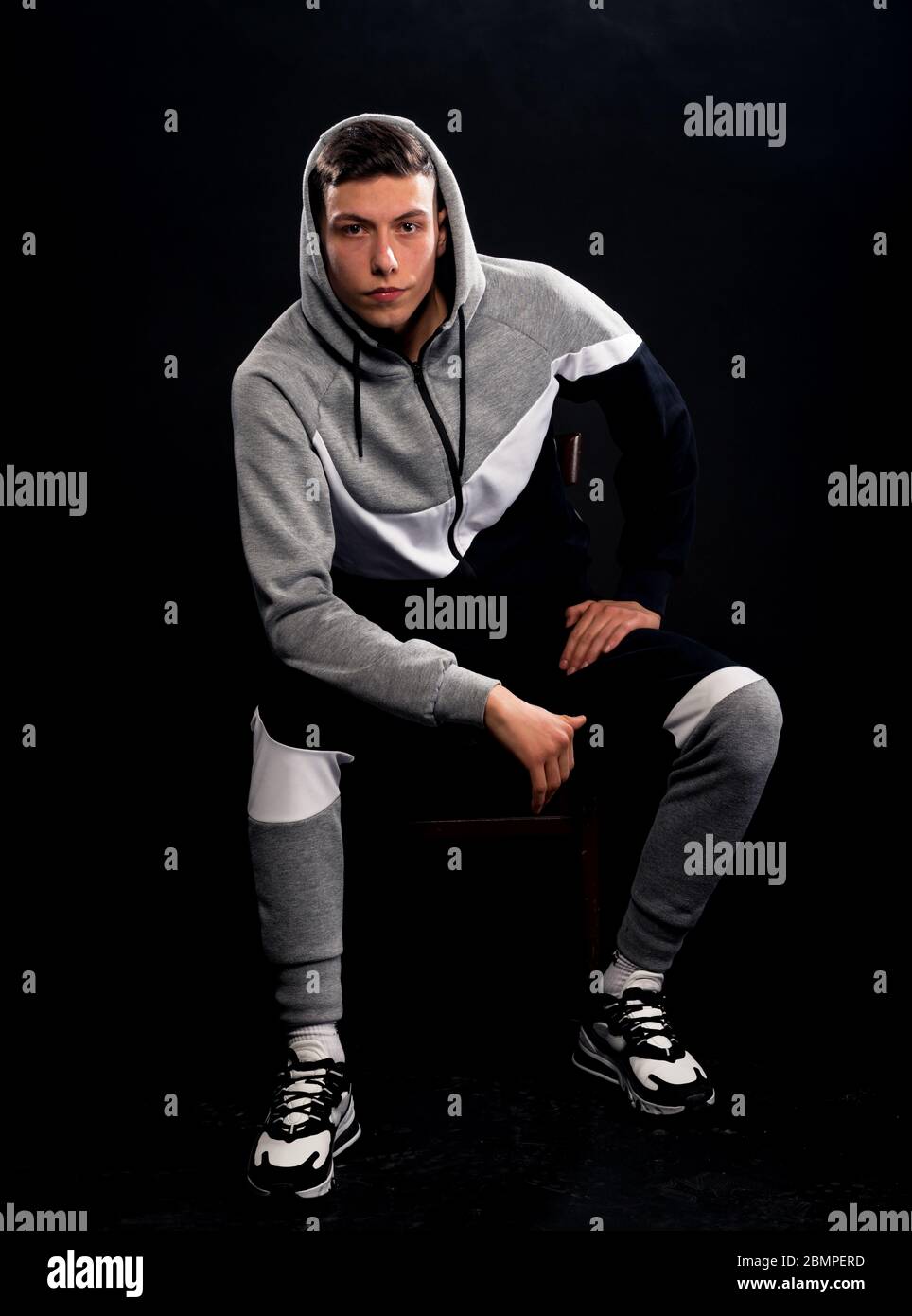 Young man in black and grey tracksuits on a black background Stock ...