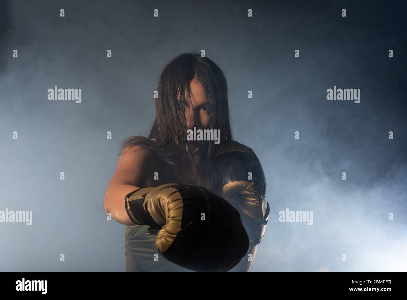 Closeup portrait of a female boxer posing with boxing gloves and ...