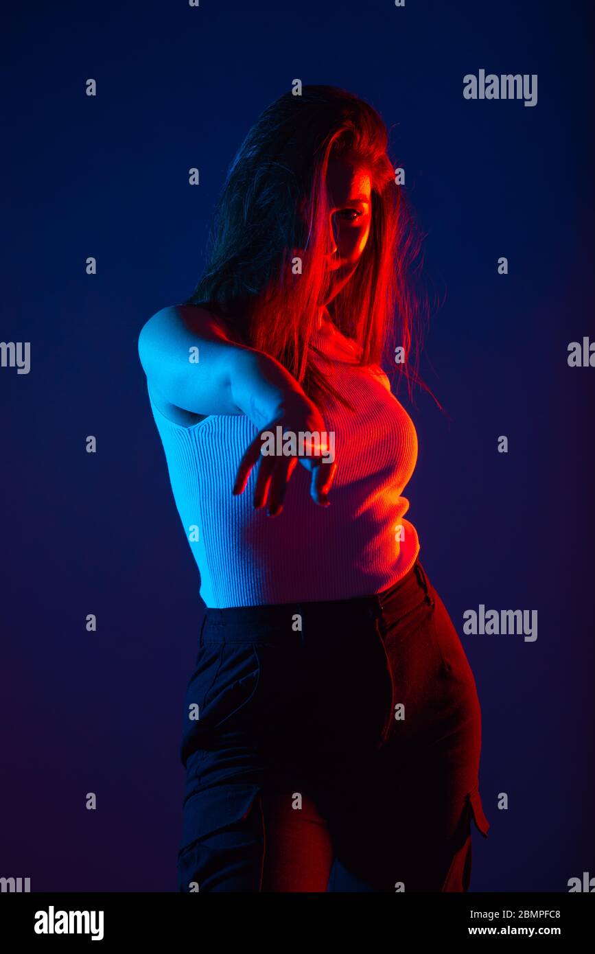 Female model posing in studio with red and blue colors at high contrast ...