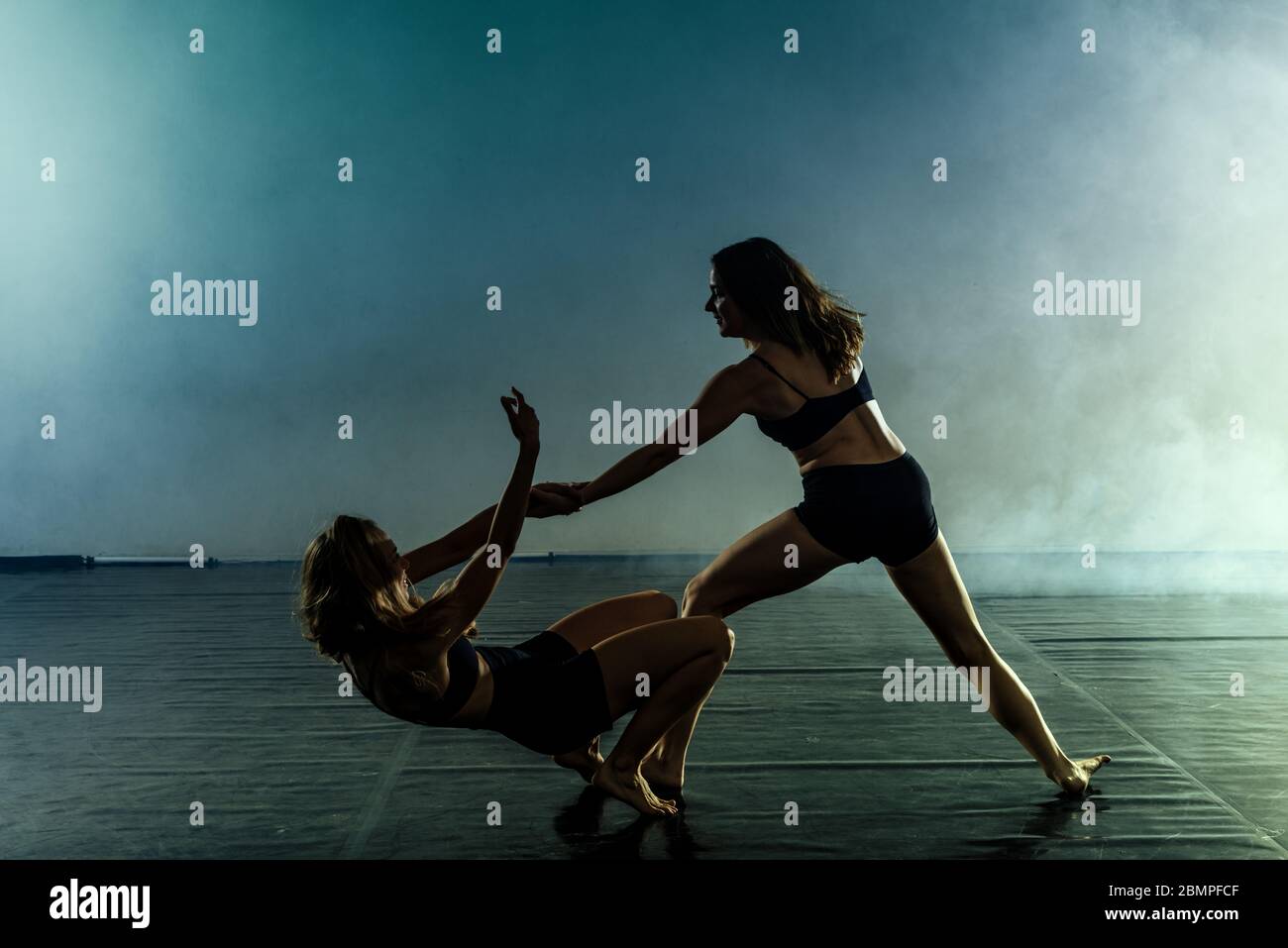 Slim athletic dance partners in tights performing modern style ballet ...