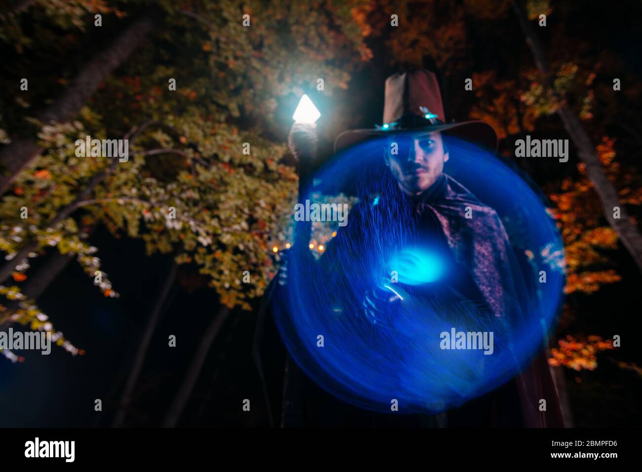 Wizard (mage) casting a spell with his magical staff while standing in ...