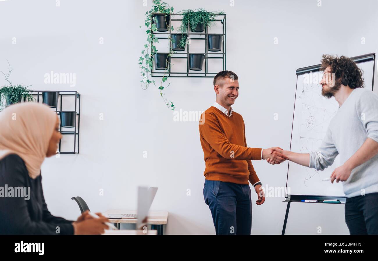 Male business coach speaker shaking hands with his colleague on the ...