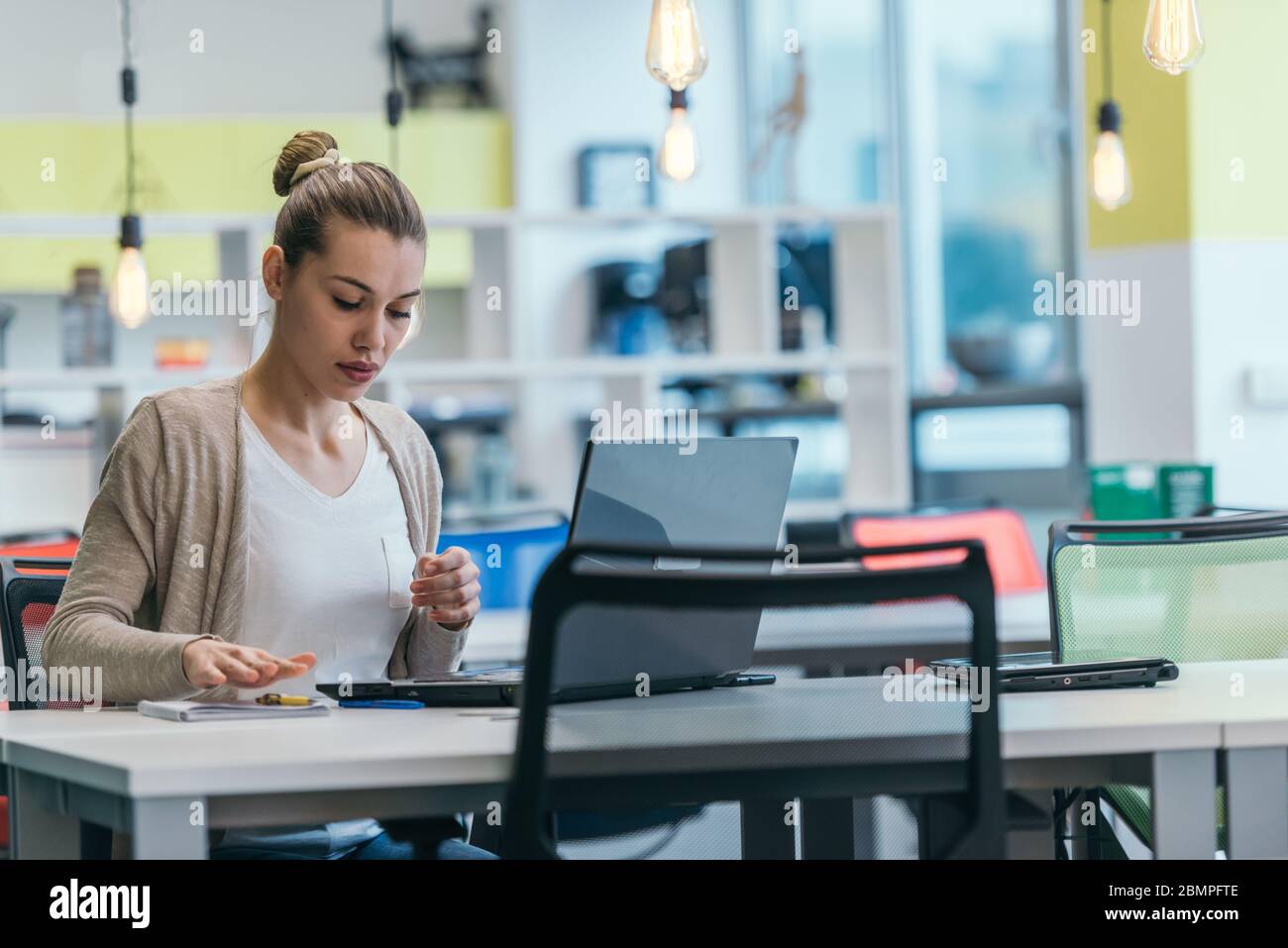 Blonde manager working behind her desk in a modern office Stock Photo ...