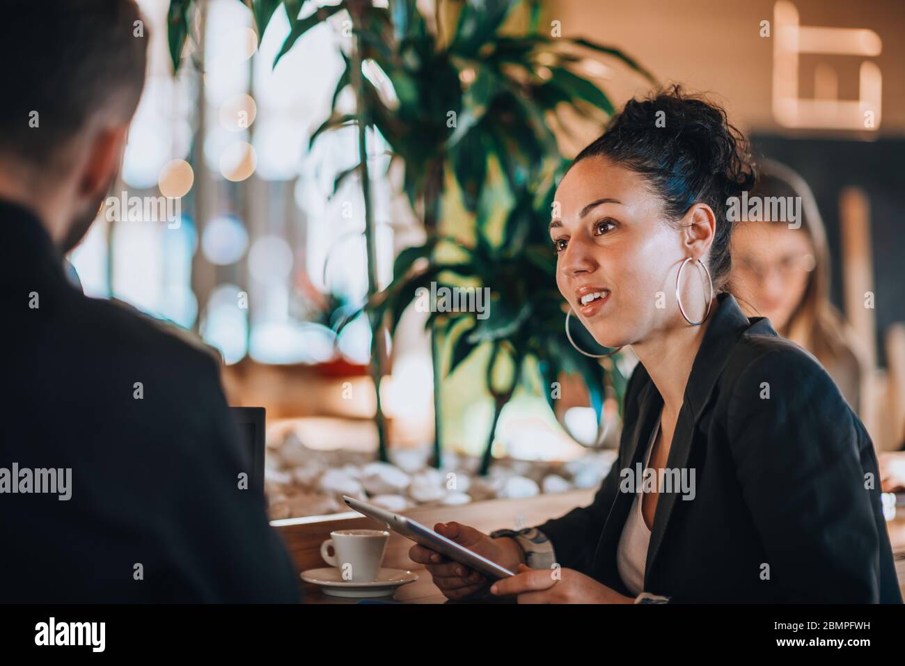 Group of coworkers hanging out in a coffee shop during a business ...
