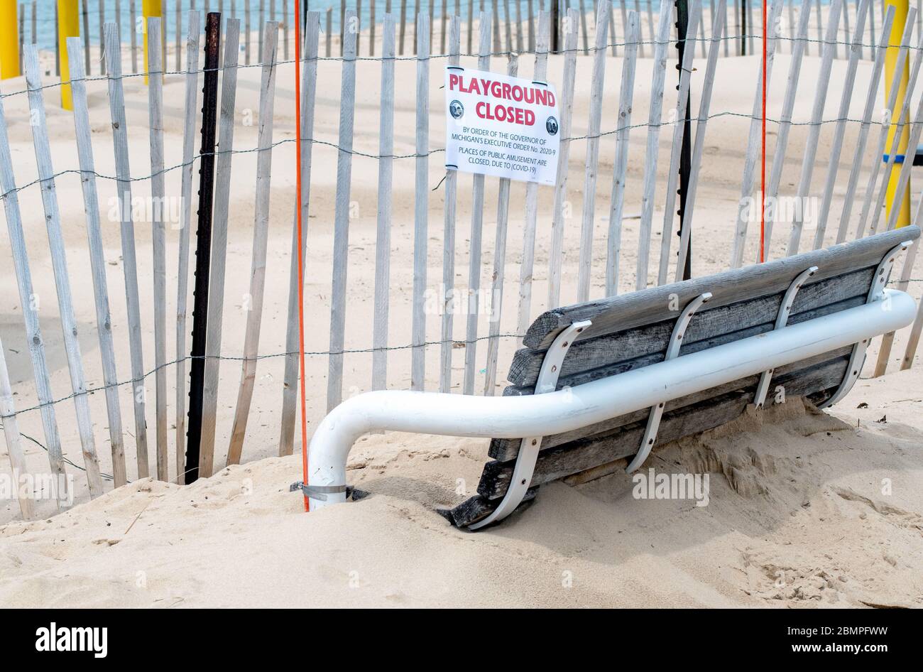 A buried park bench and a fenced off playground show how times are ...