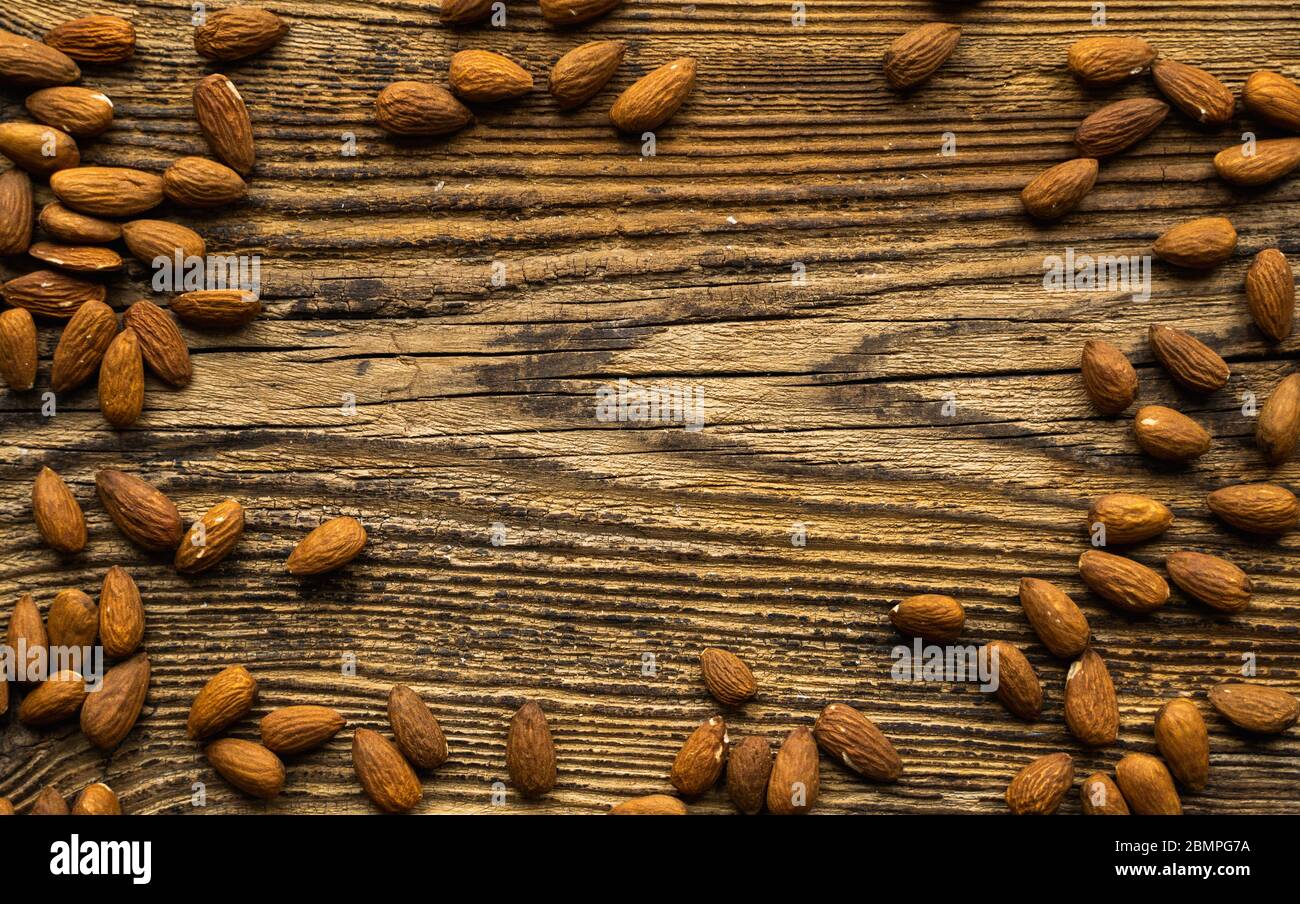 Almonds scattered on the wooden vintage table. Almond is a healthy ...