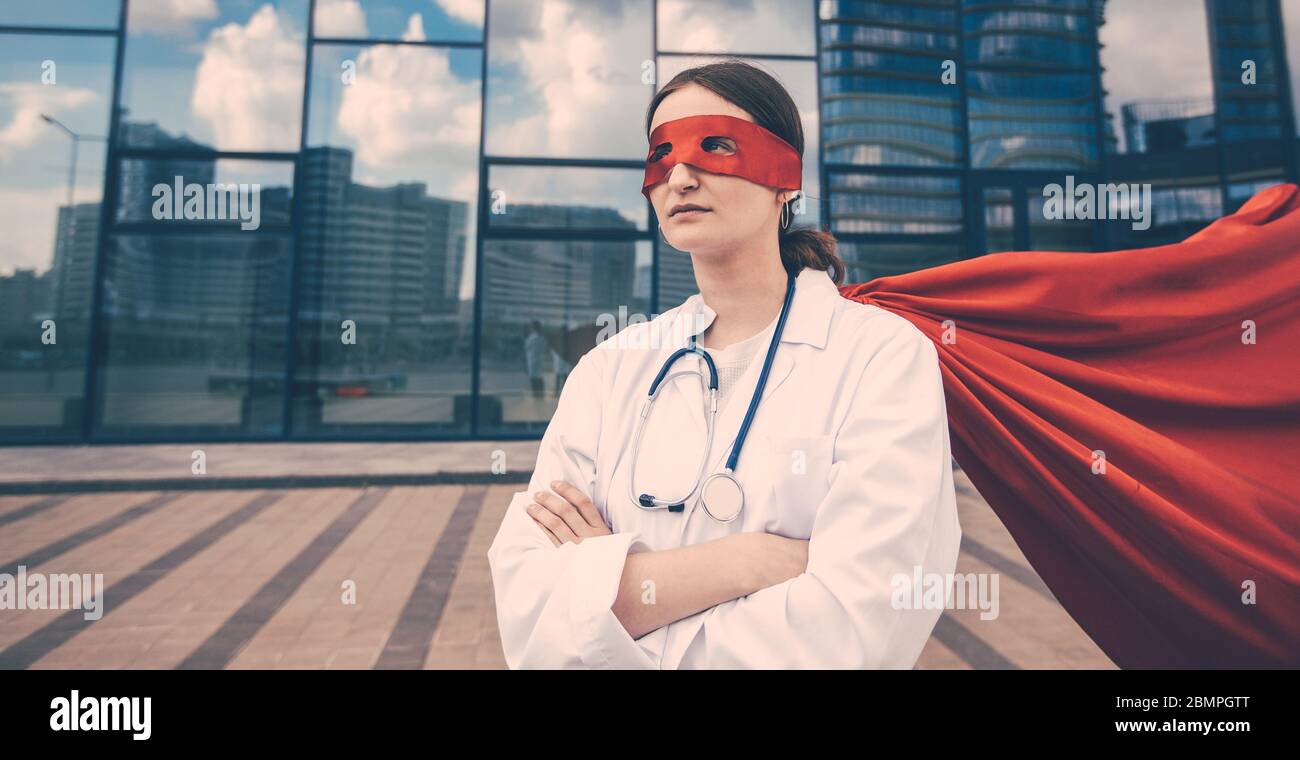 female paramedic in a superhero raincoat standing on a city street ...