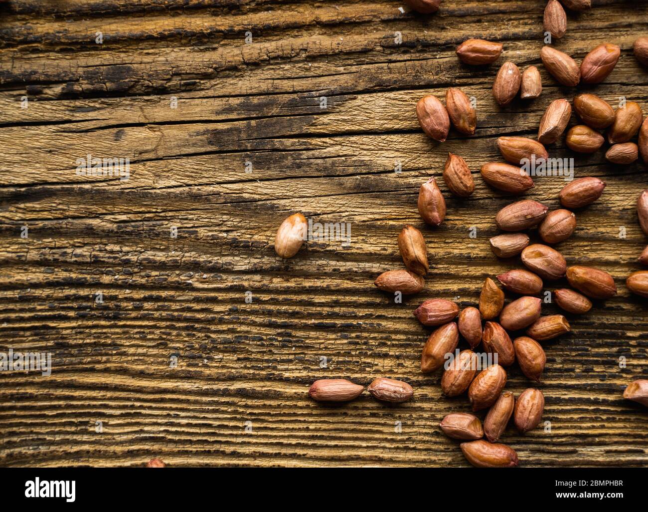 Peanut nuts scattered on the wooden vintage table. Peanuts nut is a ...