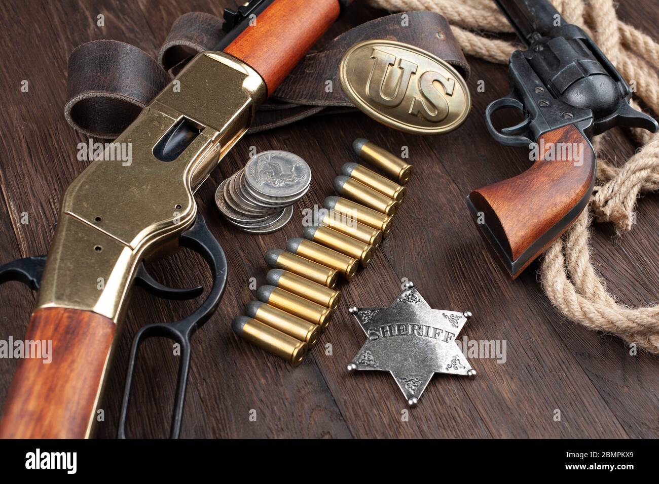 Wild west weapons, ammunition and sheriff badge with silver dollars on ...